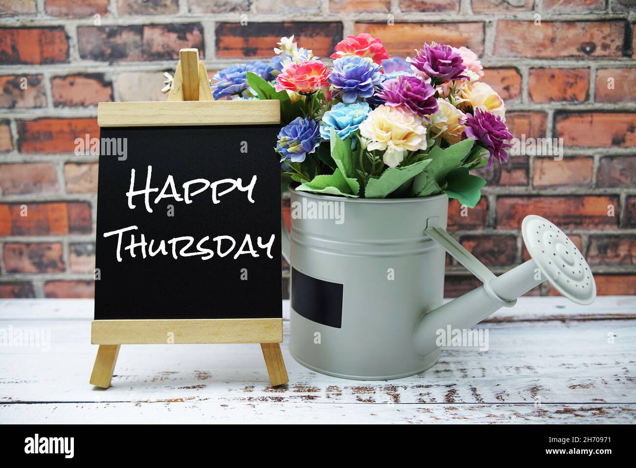 Happy Thursday text on black wooden easel and vase with flowers bouquet ...