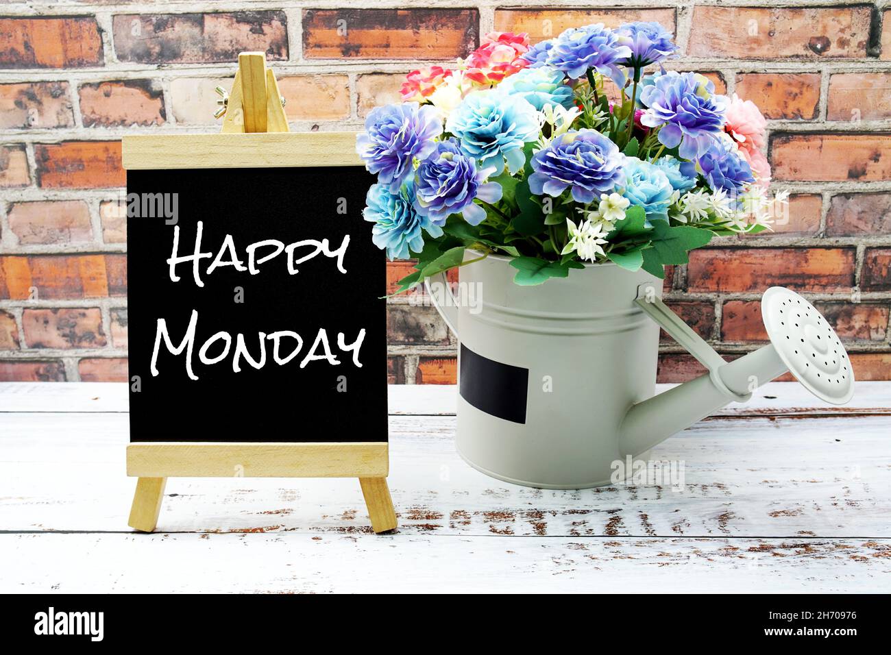 Happy Monday text on black wooden easel and vase with flowers bouquet ...