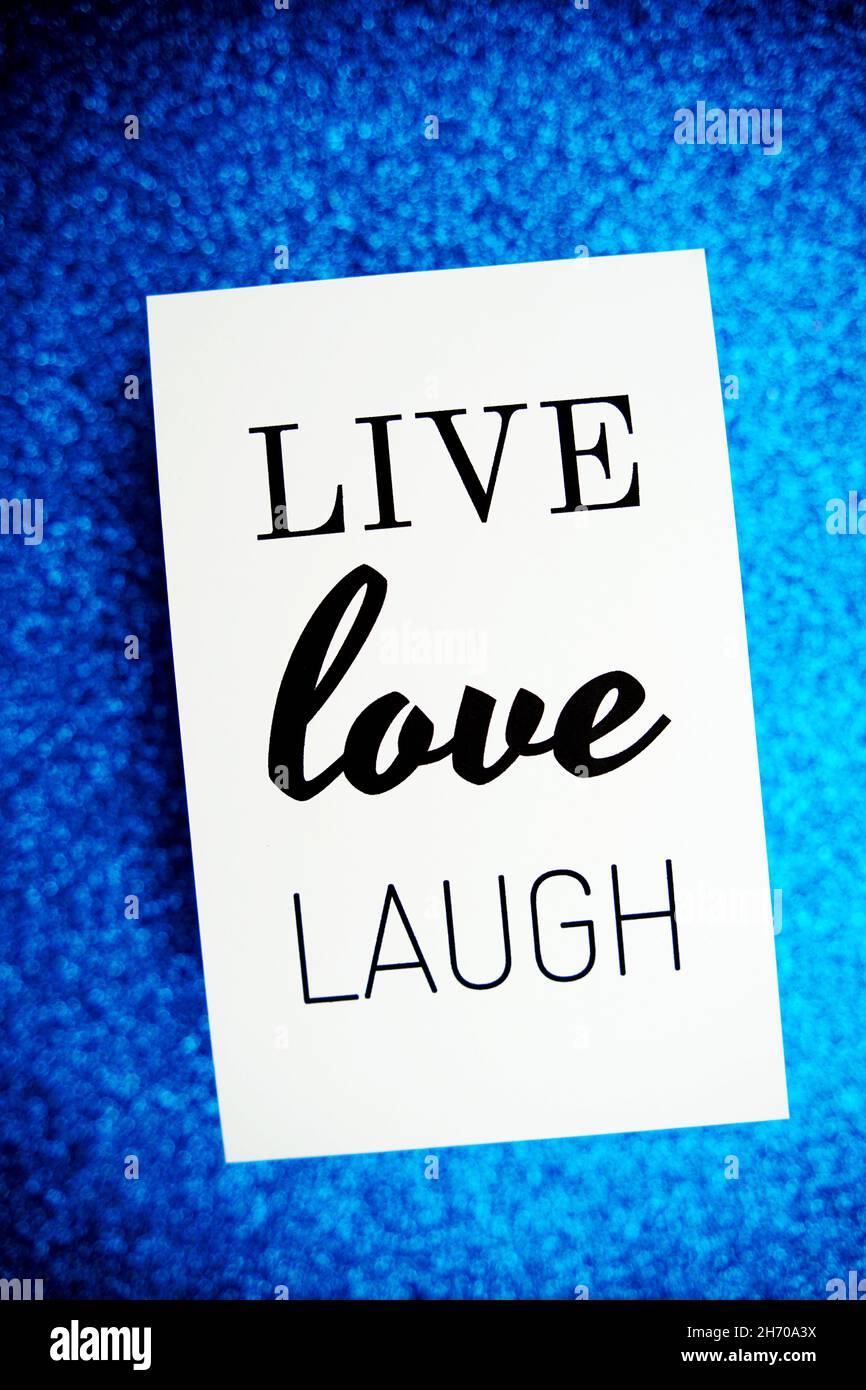 Live Love Laugh text on paper card top view on blue bokeh background ...