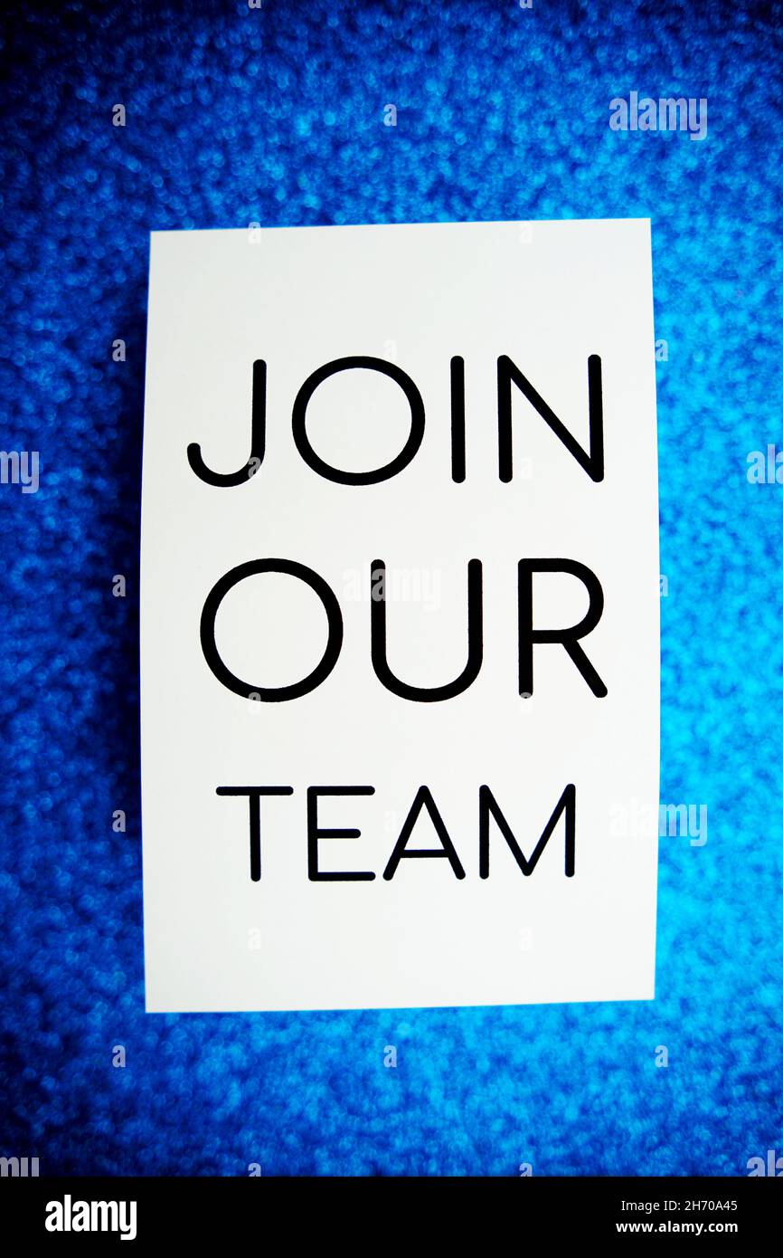 Join our team text on paper card top view on blue bokeh background ...