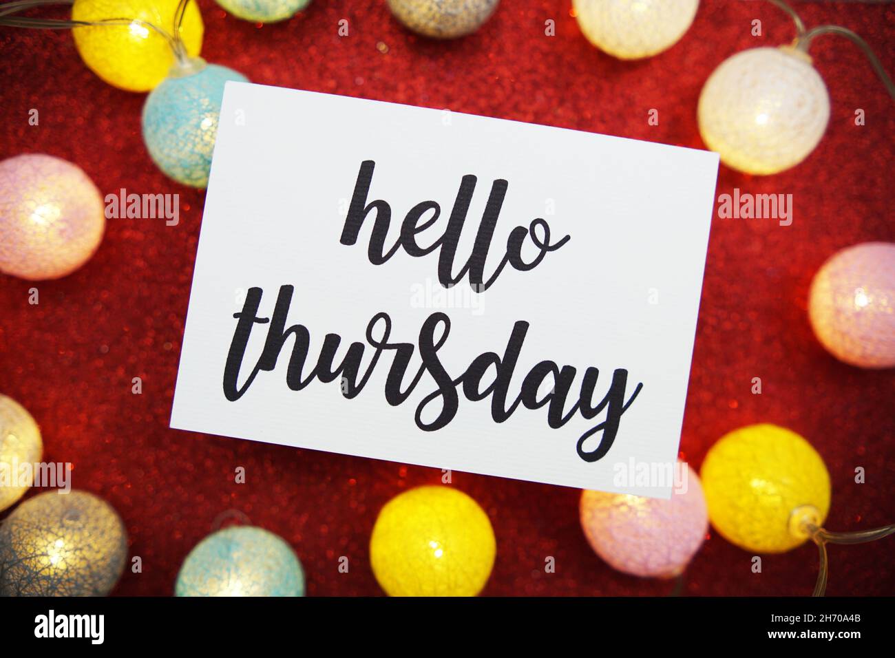 Hello Thursday text on paper card top view on red bokeh background ...