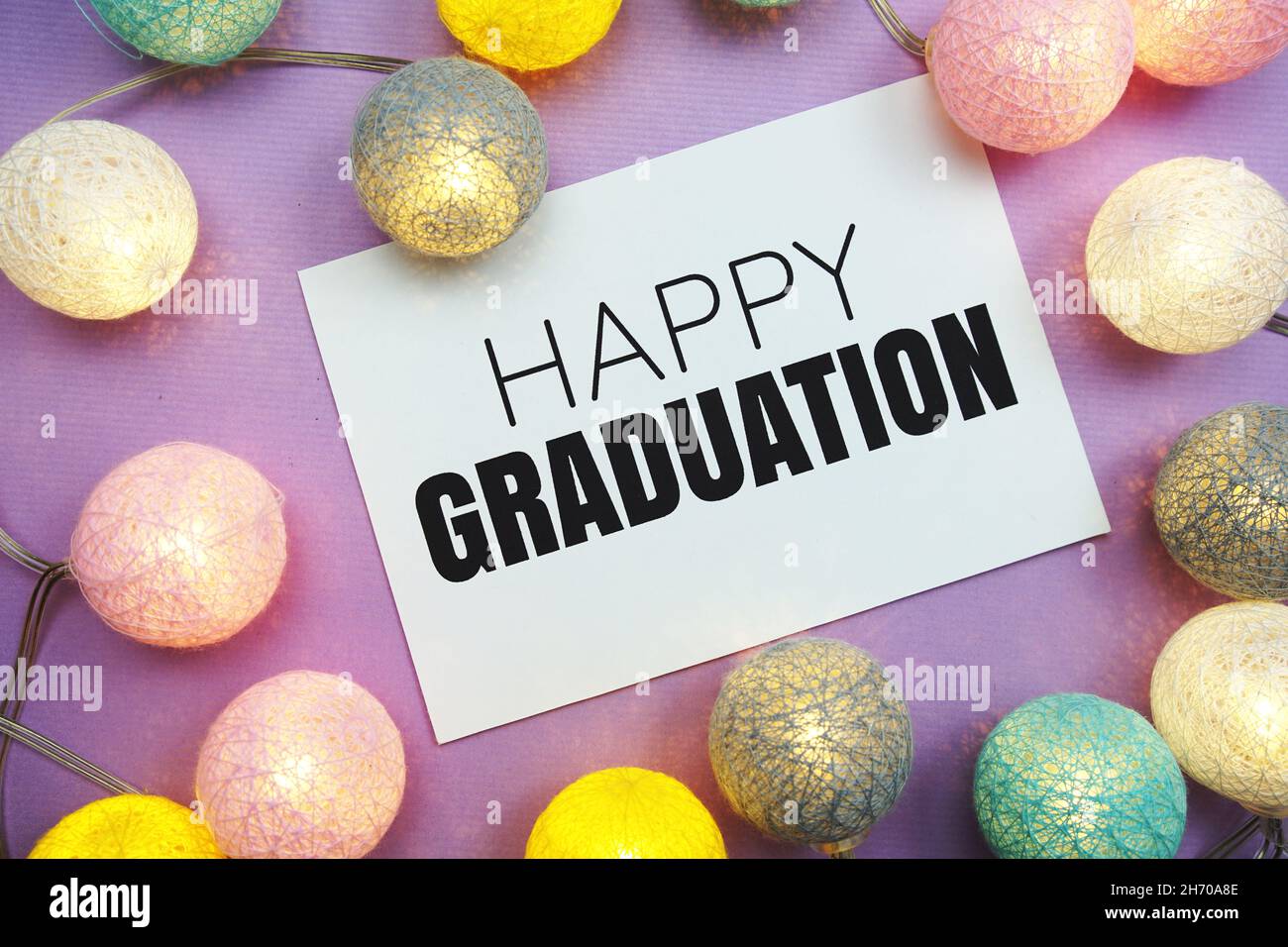 Happy Graduation text with LED cotton balls decoration on purple ...
