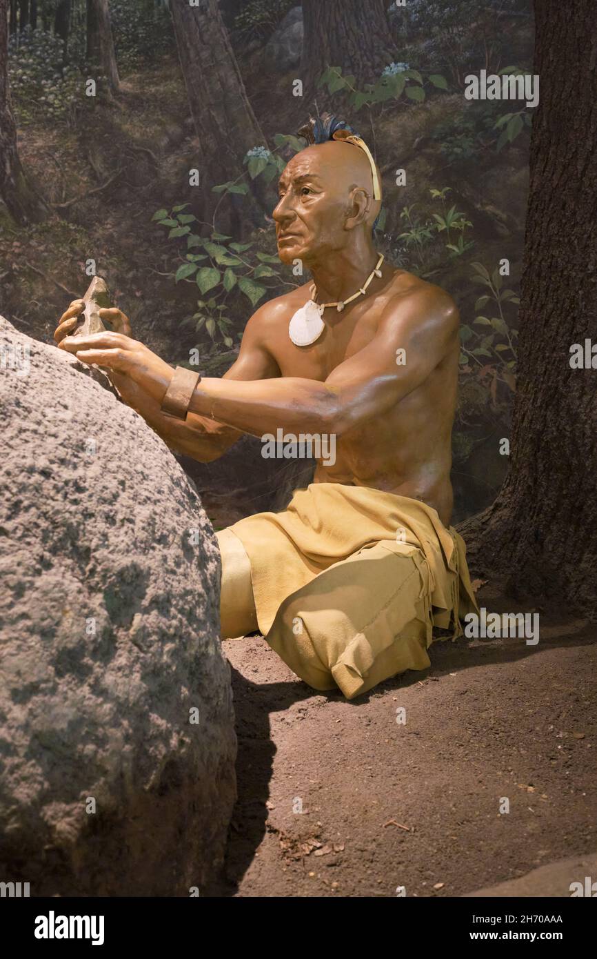 A Native American Diorama exhibit, display of a man carving with a rock ...