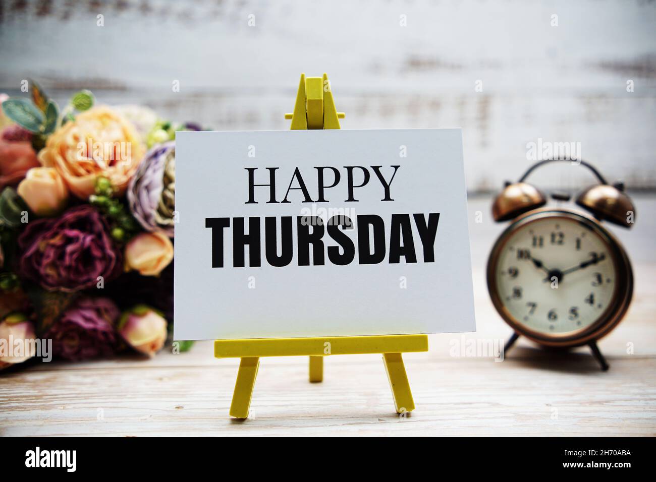 Happy Thursday text with flower bouquet and alarm clock on wooden ...