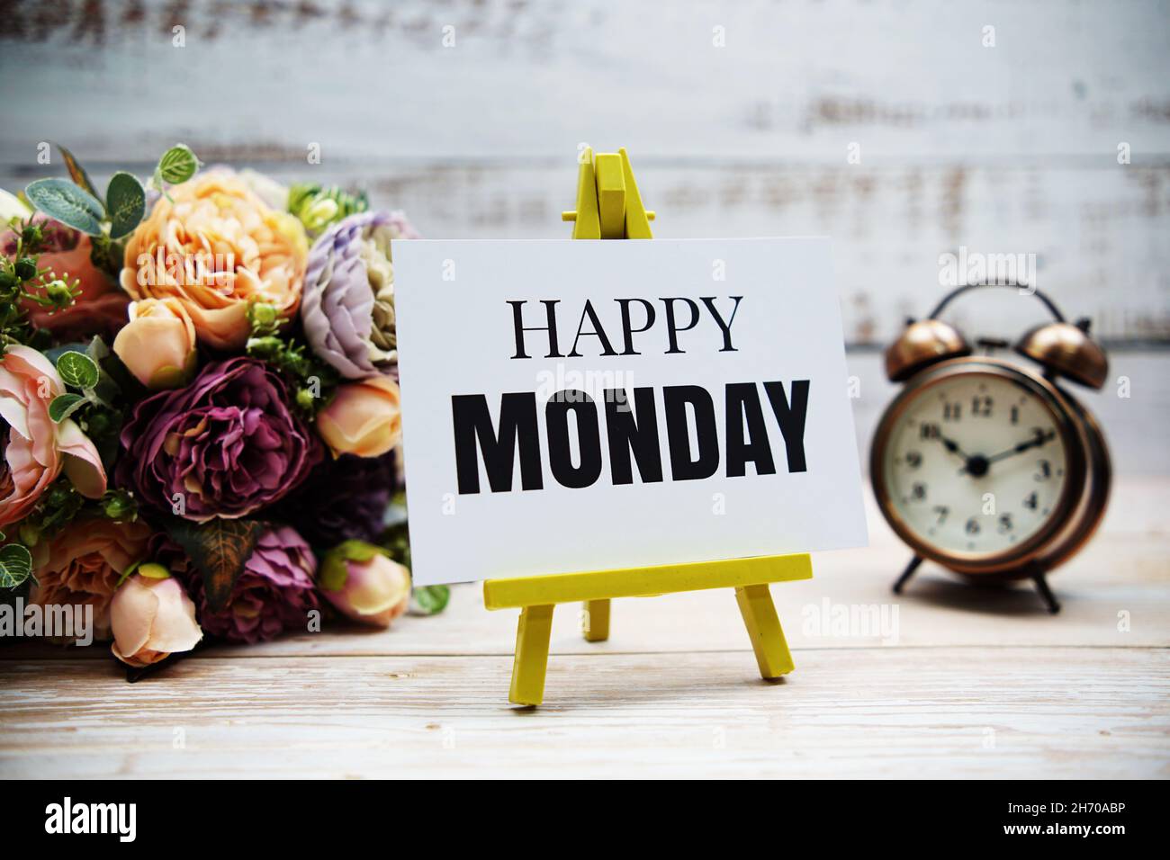 Happy Monday text with flower bouquet and alarm clock on wooden ...