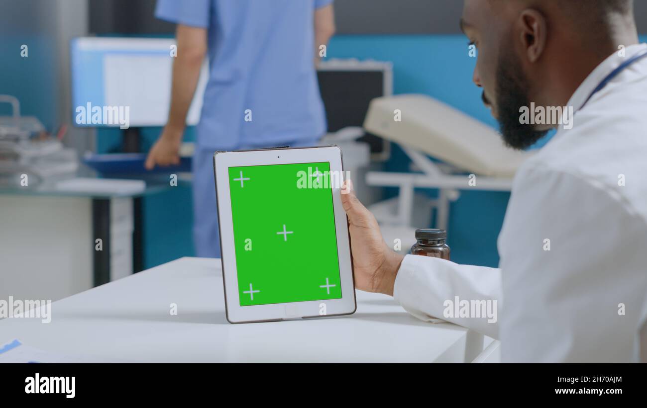 African american specialist doctor looking at mock up green screen ...