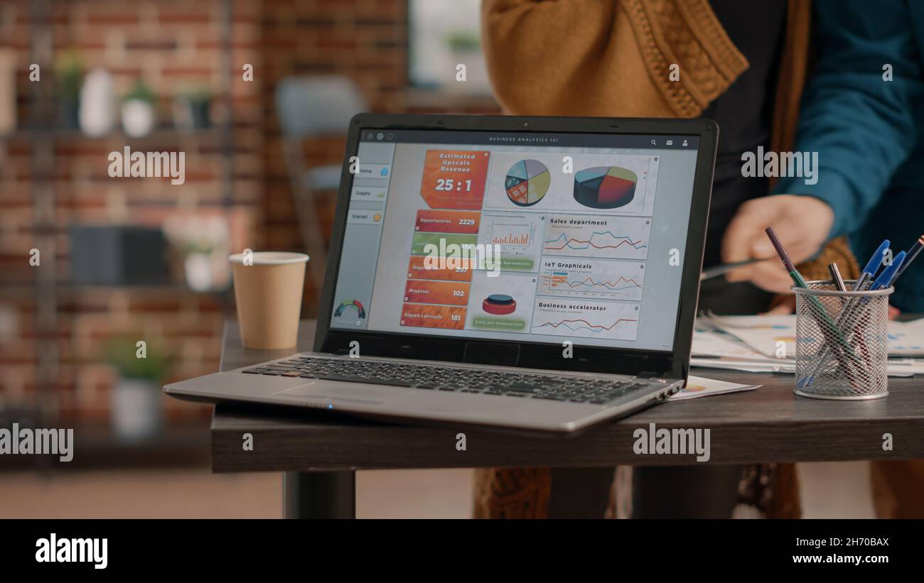 Close up of laptop with chart rate information on desk used by business ...