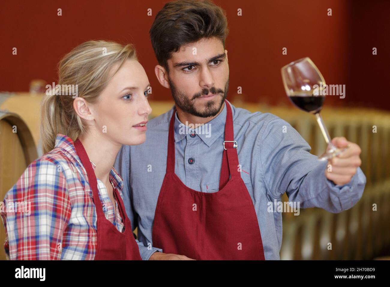 winery workers holding a glass of wine in aging section Stock Photo - Alamy