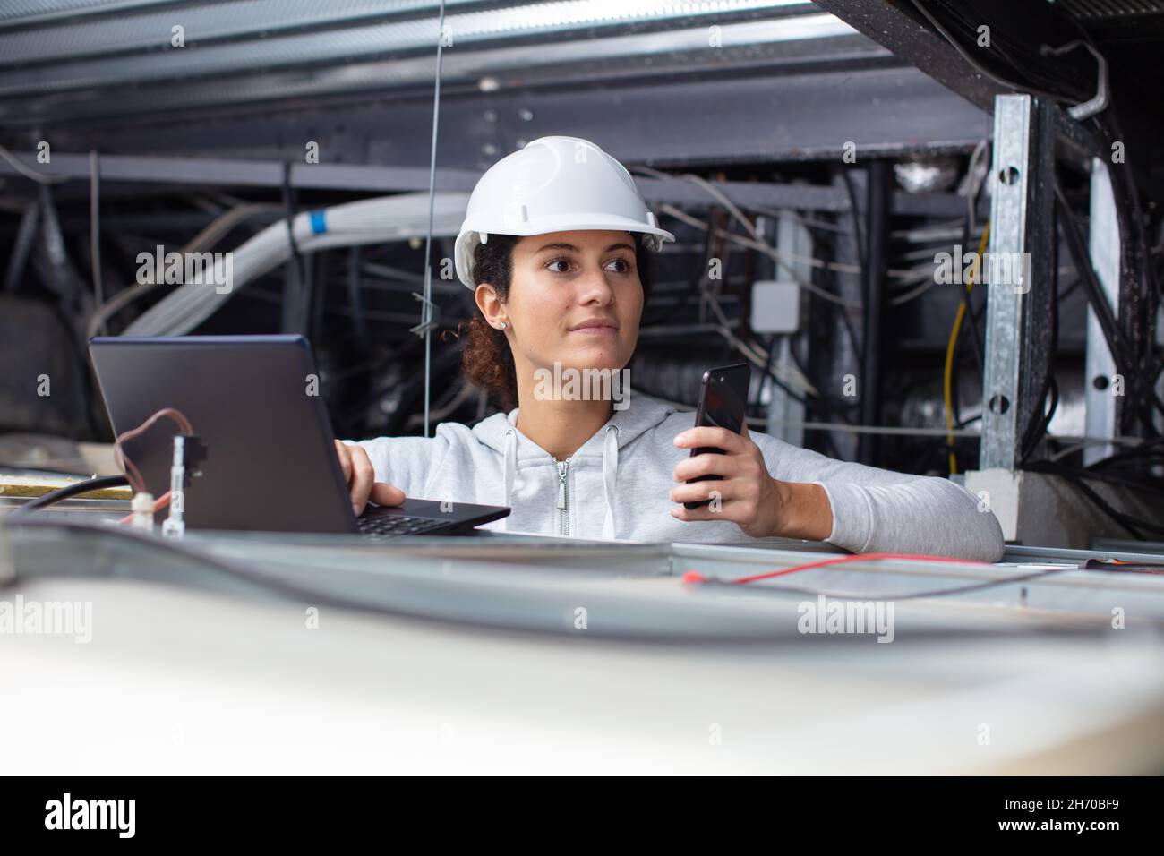 female electrician installing electric device in ceiling Stock Photo ...