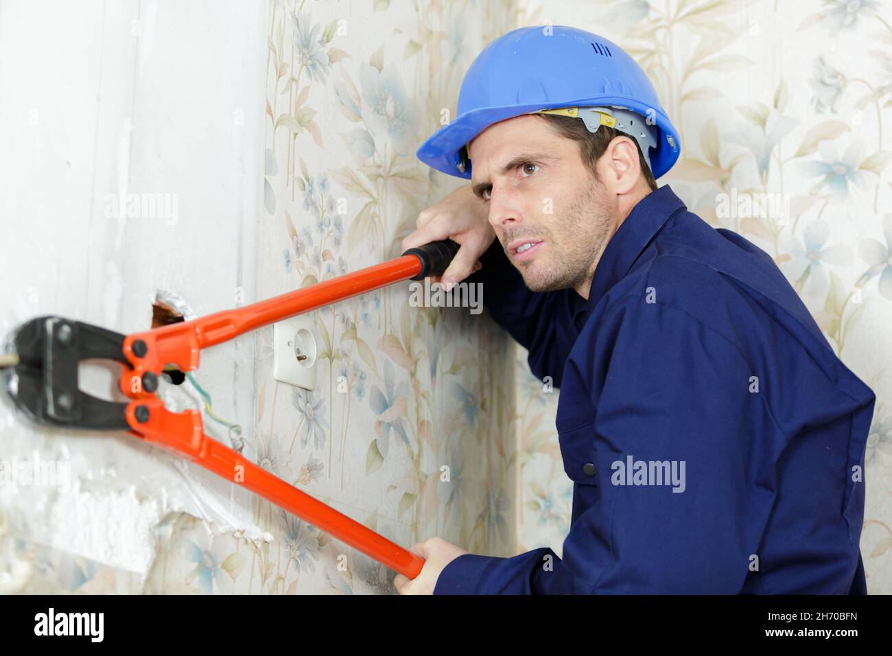 male builder with pliers indoors Stock Photo - Alamy