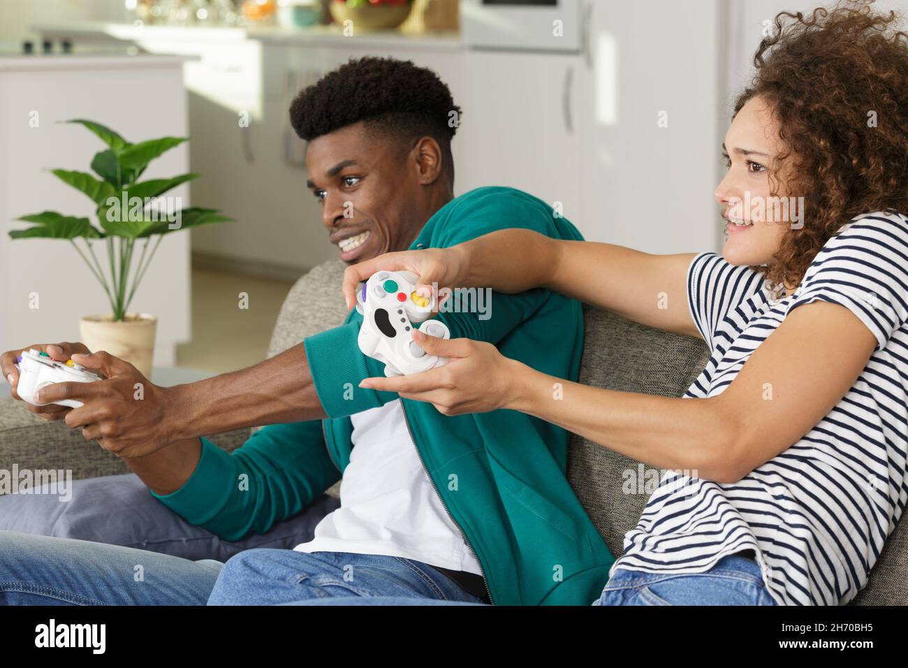couple jostling eachother while playing computer game Stock Photo - Alamy