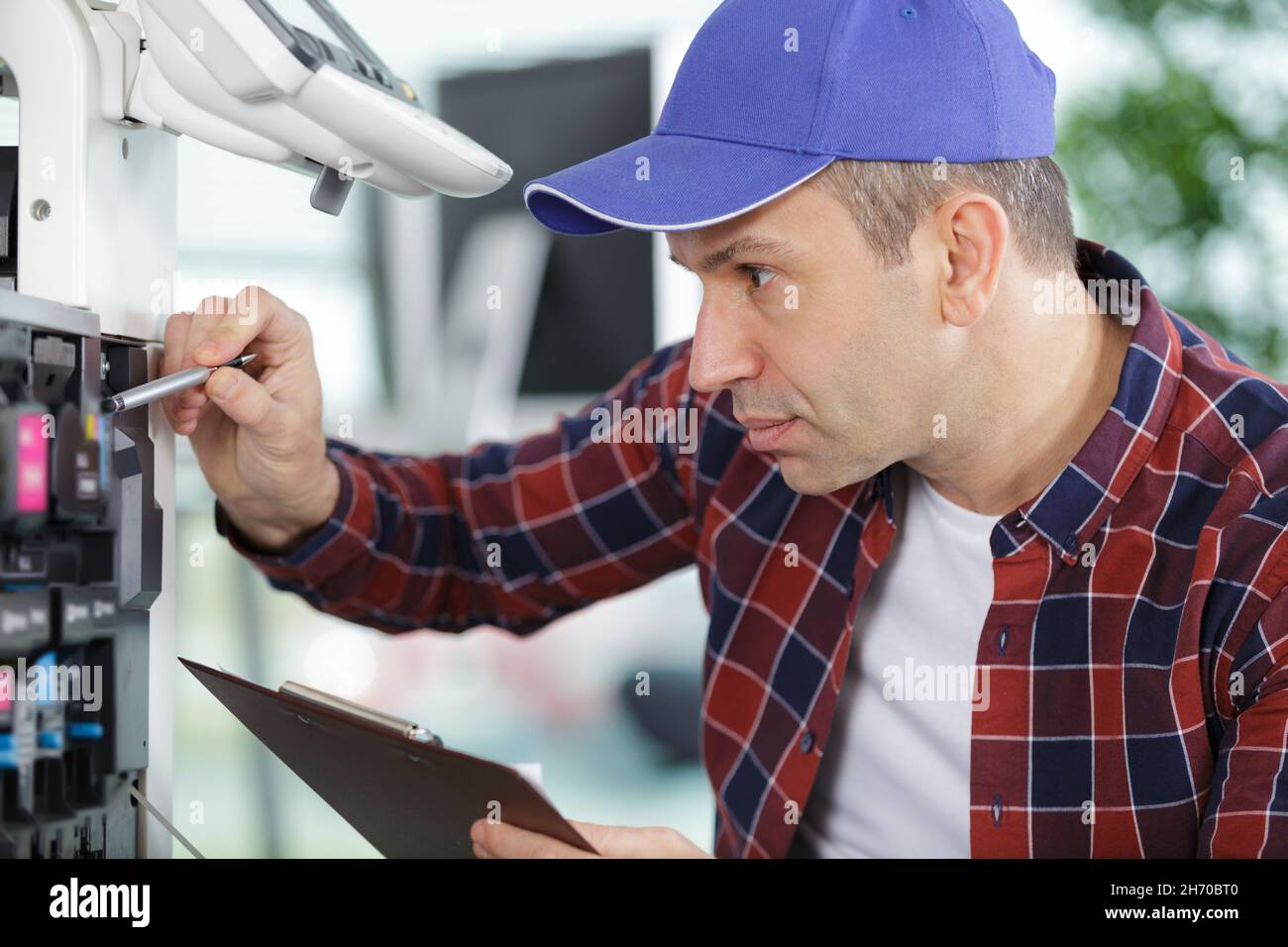 maintenance checks the level of ink of printer at work Stock Photo - Alamy
