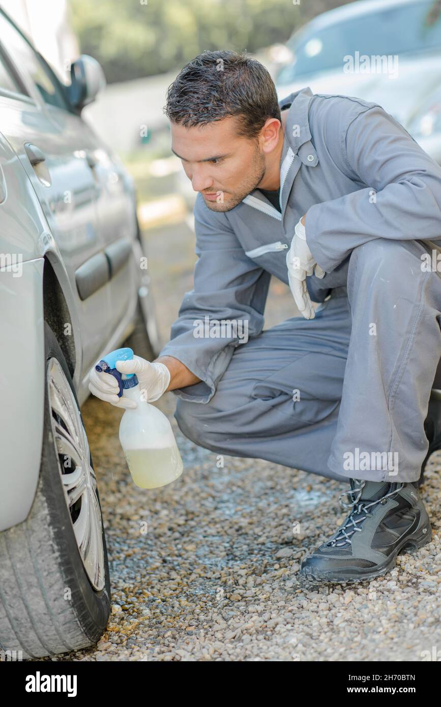 Mechanic spraying car from plastic bottle Stock Photo - Alamy