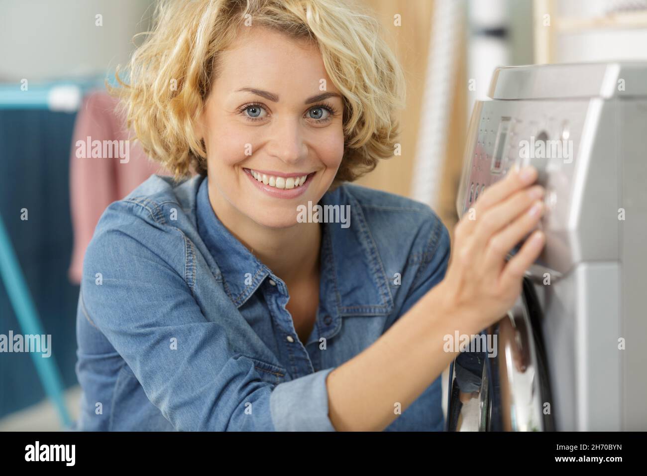 young woman operates a washing machine Stock Photo - Alamy