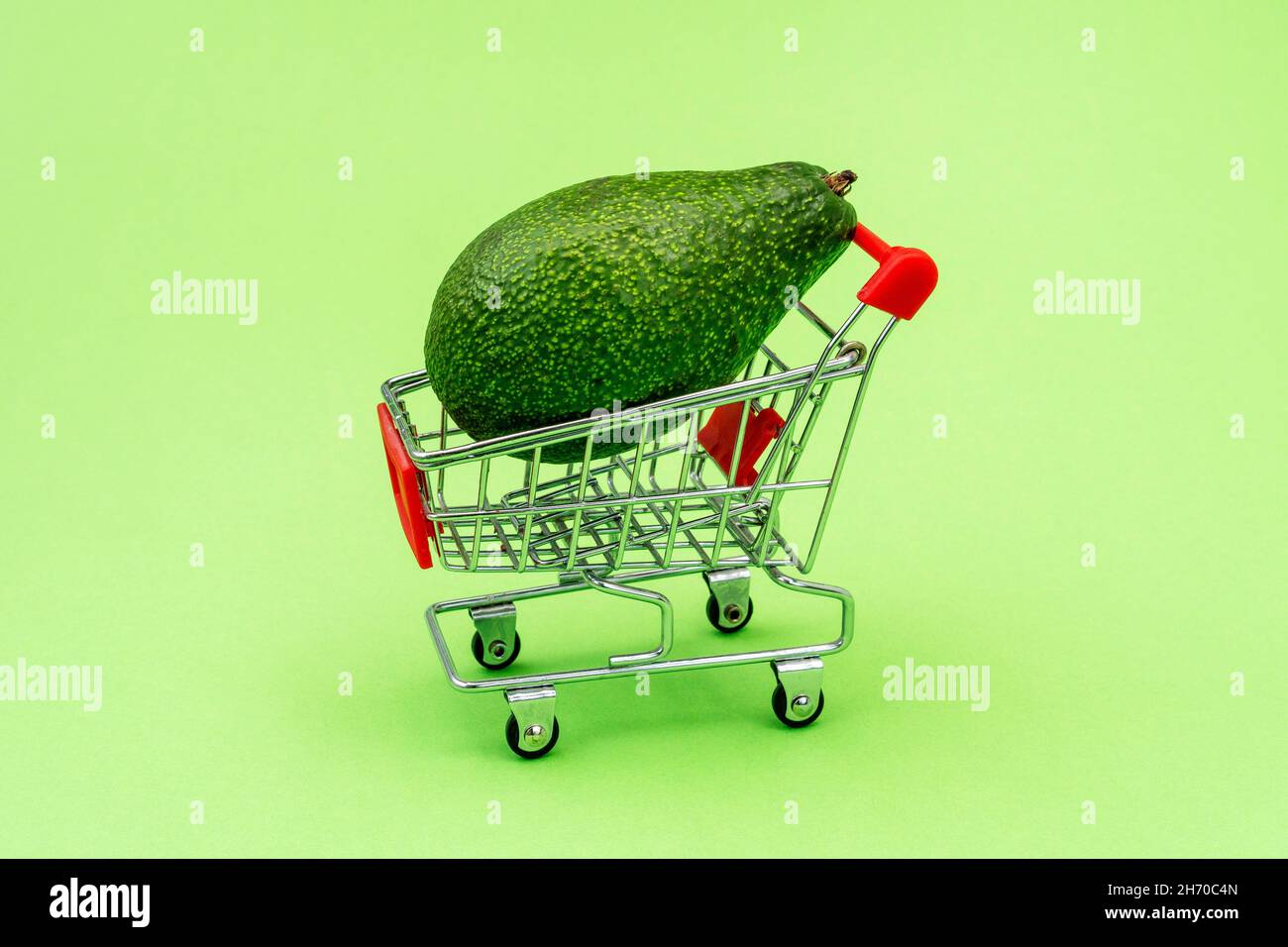 Avocado in shopping grocery cart. Shopping at the supermarket. Fresh ...