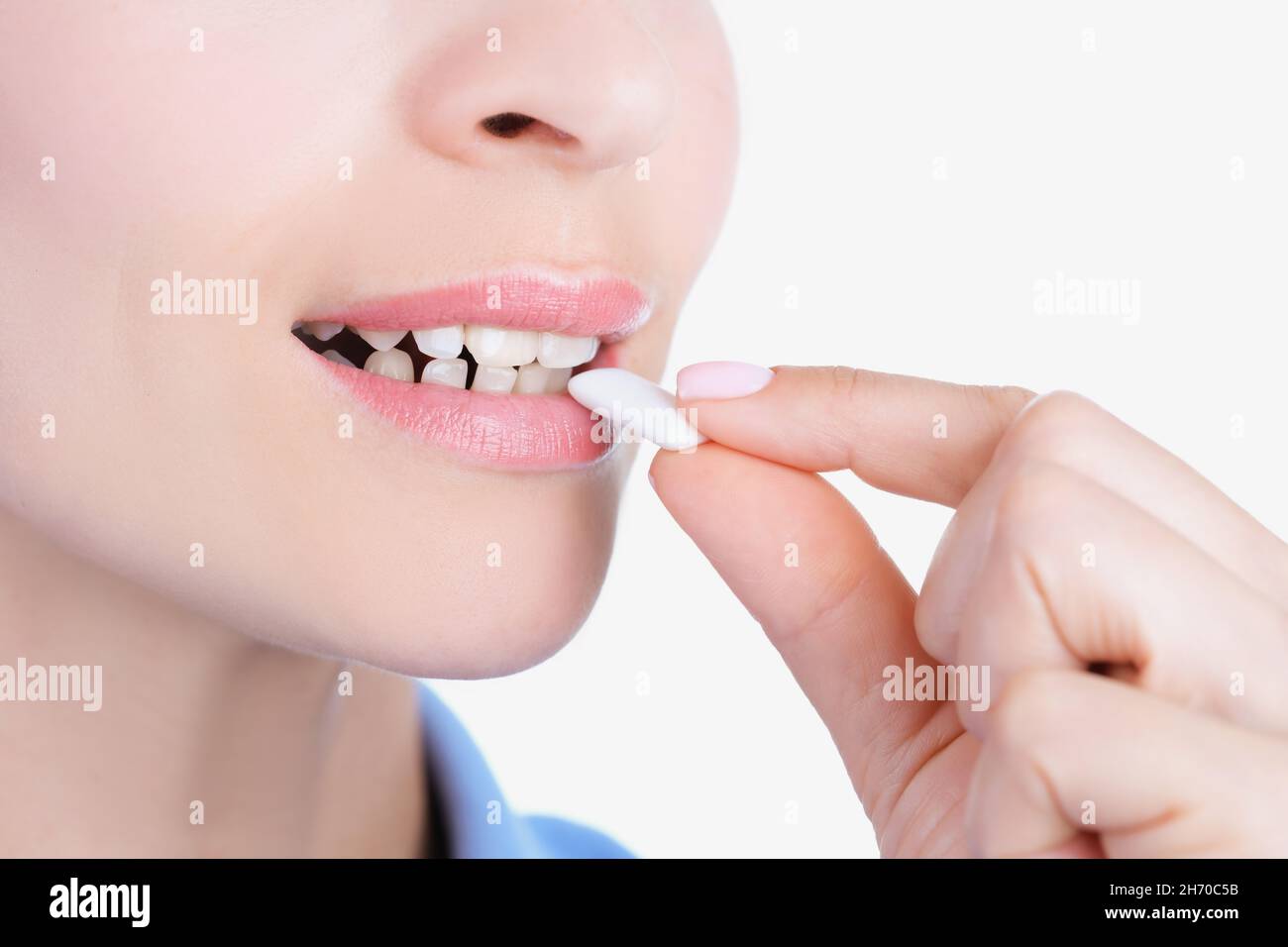 Womans face and female hand putting into mouth chewing gum Stock Photo ...