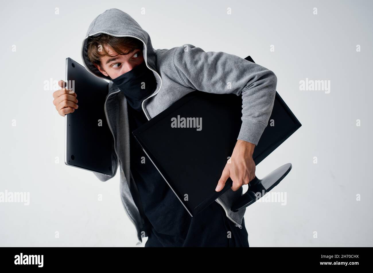 male thief hooded head hacking technology security light background ...