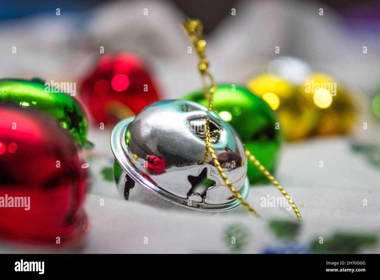 Multi-colored jingle bells on a light background. Selective focus ...