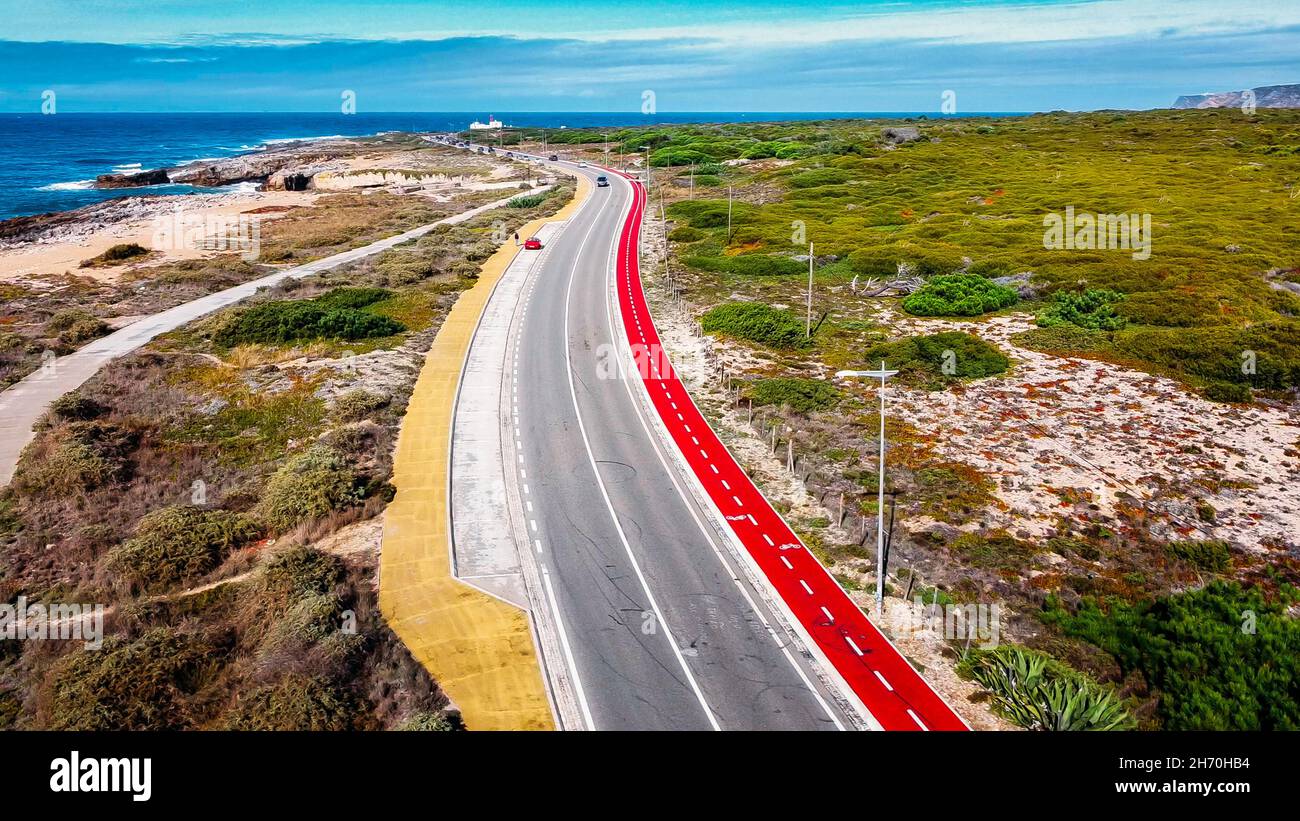 Aerial view top down view of of a straight road and rugged coastline at ...