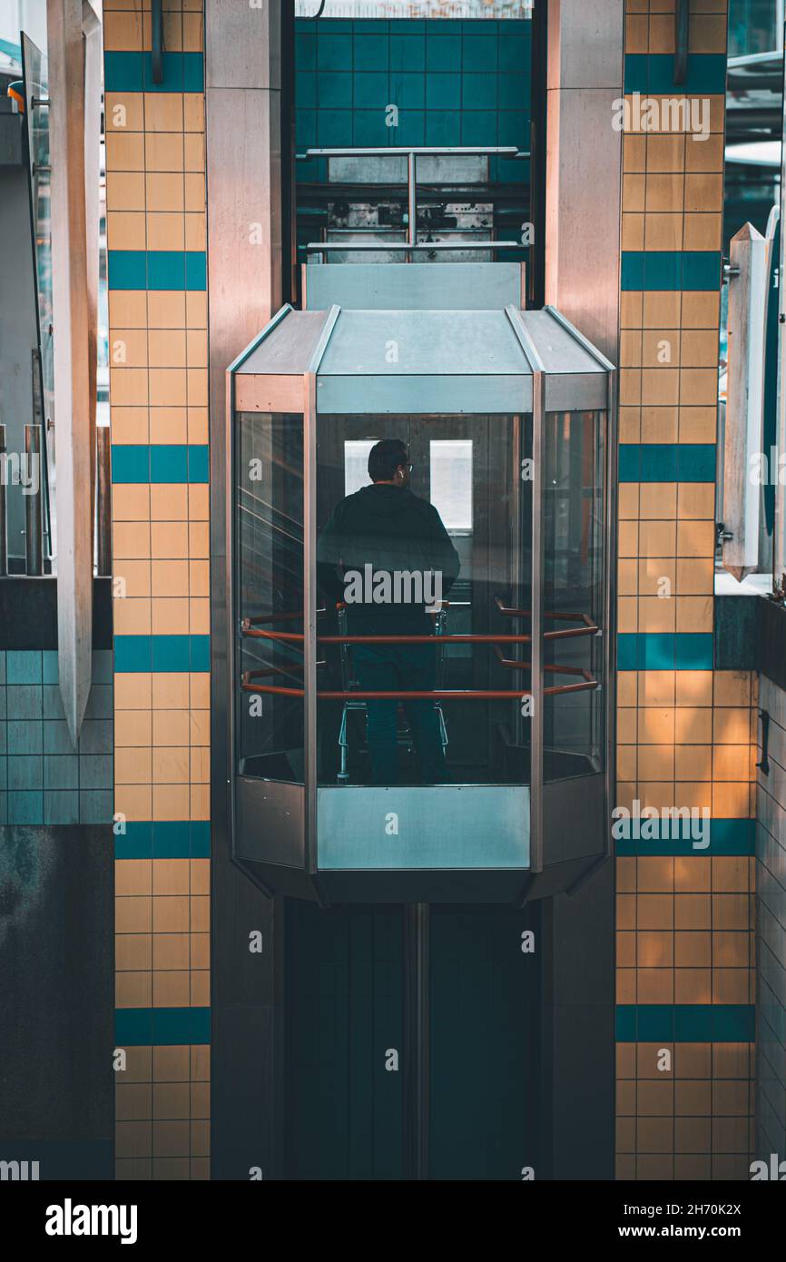 Vertical shot of a man in an outdoor elevator Stock Photo - Alamy