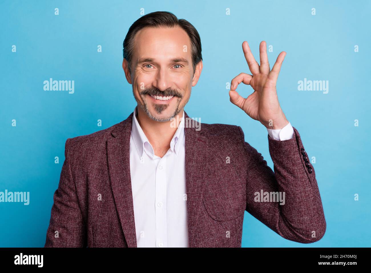 Photo of reliable smart businessman fingers show okey sign wear red ...