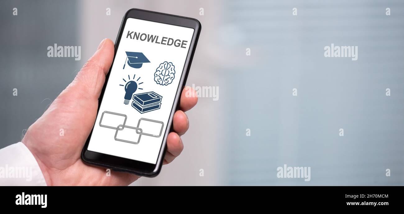 Hand holding a smartphone with knowledge concept Stock Photo - Alamy