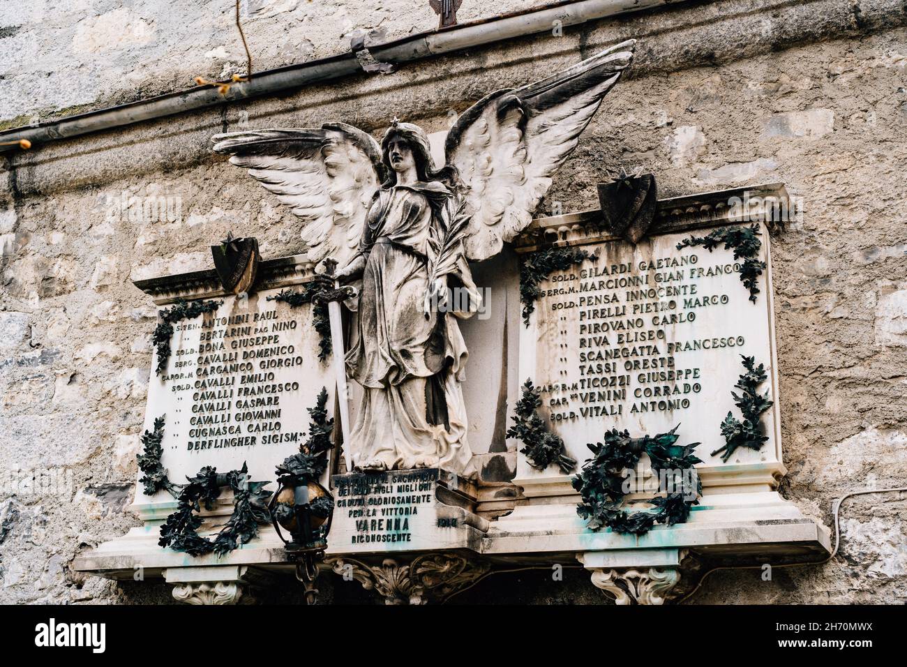 Memorial panel with a sculpture of an angel in the Varenna cemetery ...