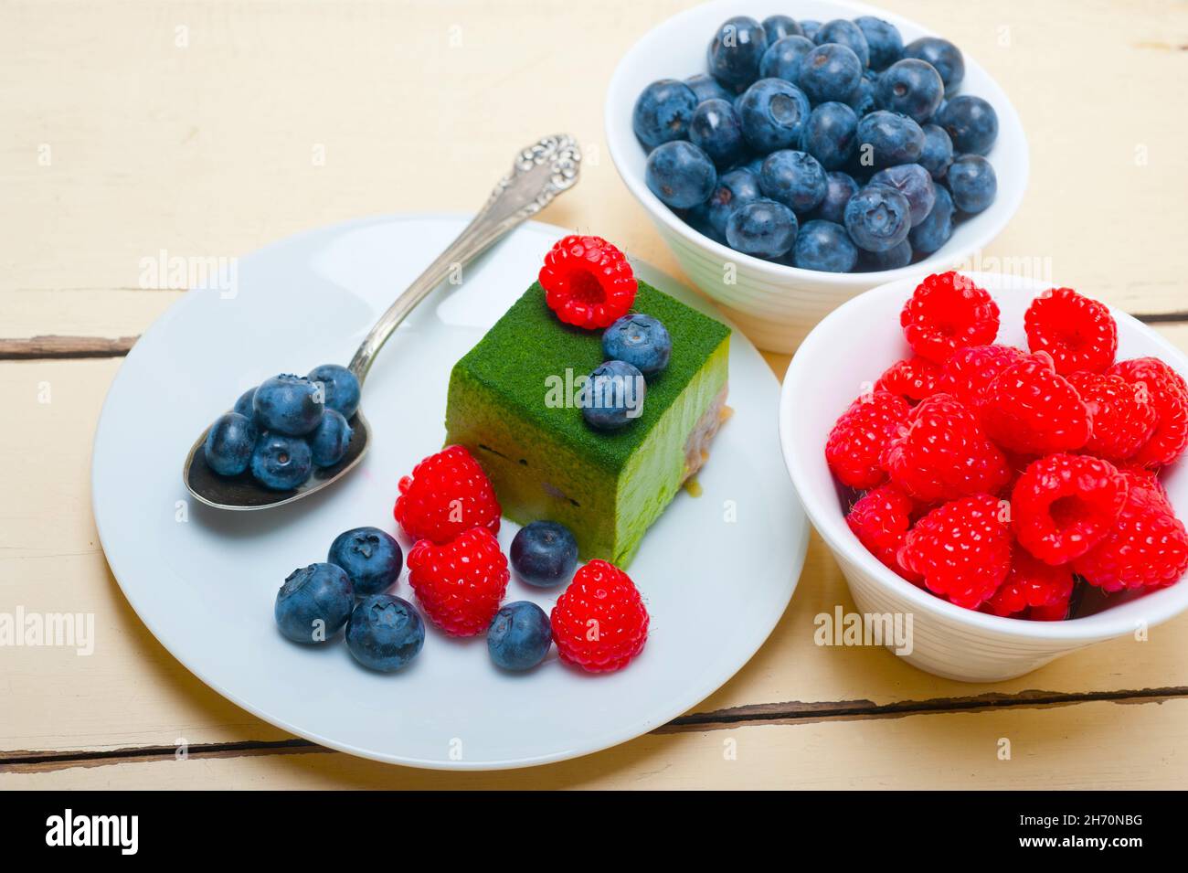 green tea matcha mousse cake with raspberries and blueberries on top ...
