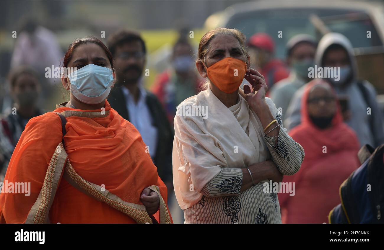 New Delhi, India. 19th Nov, 2021. People wear protective masks as they ...
