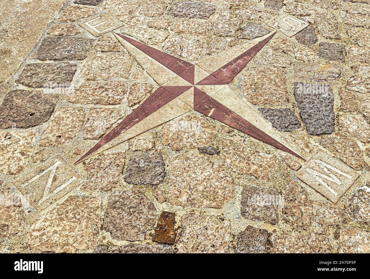 A navigational compass laid out on the pavement. Arrows pointing north ...