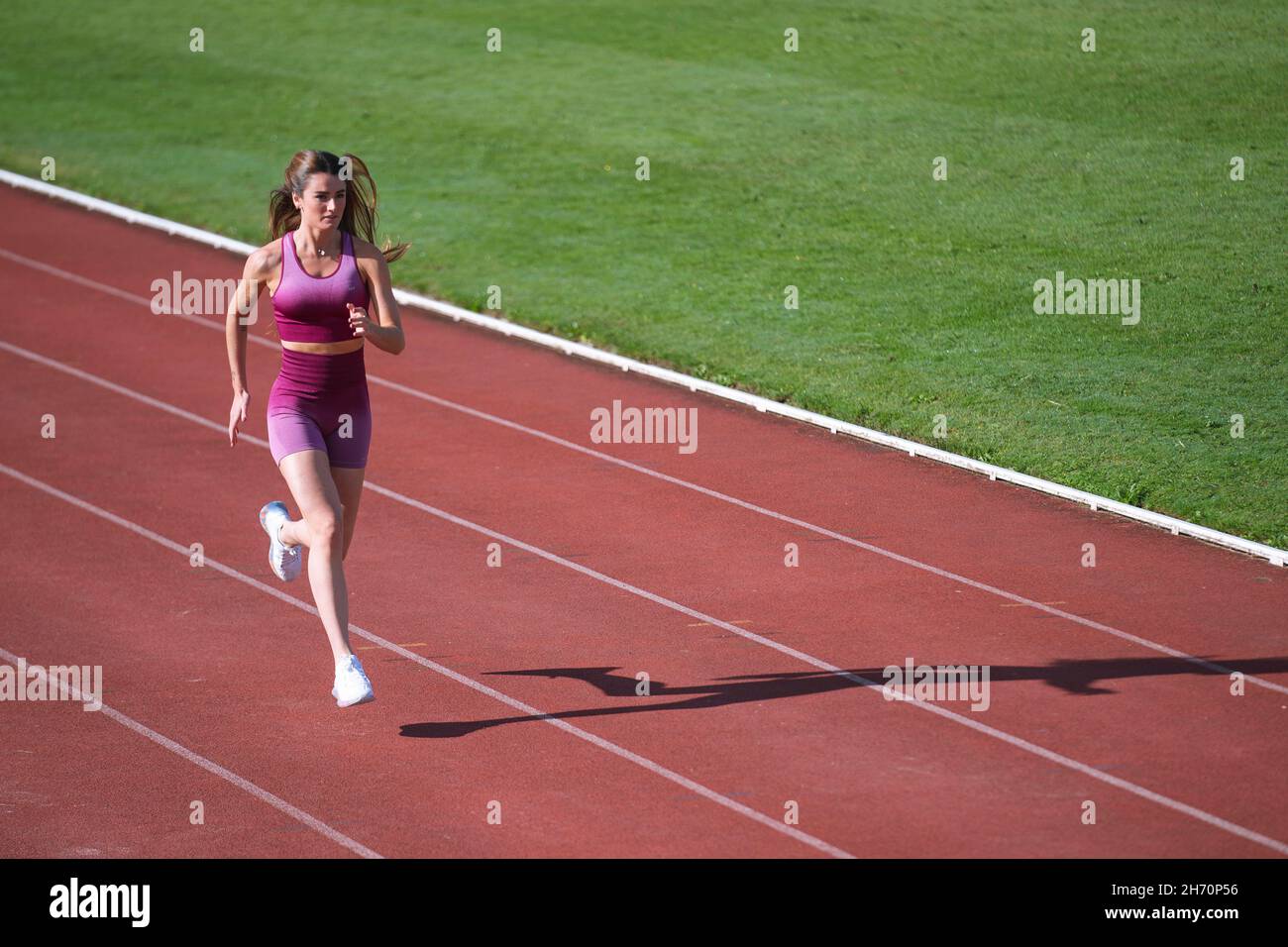 Girl model athlete running on the running track Stock Photo - Alamy