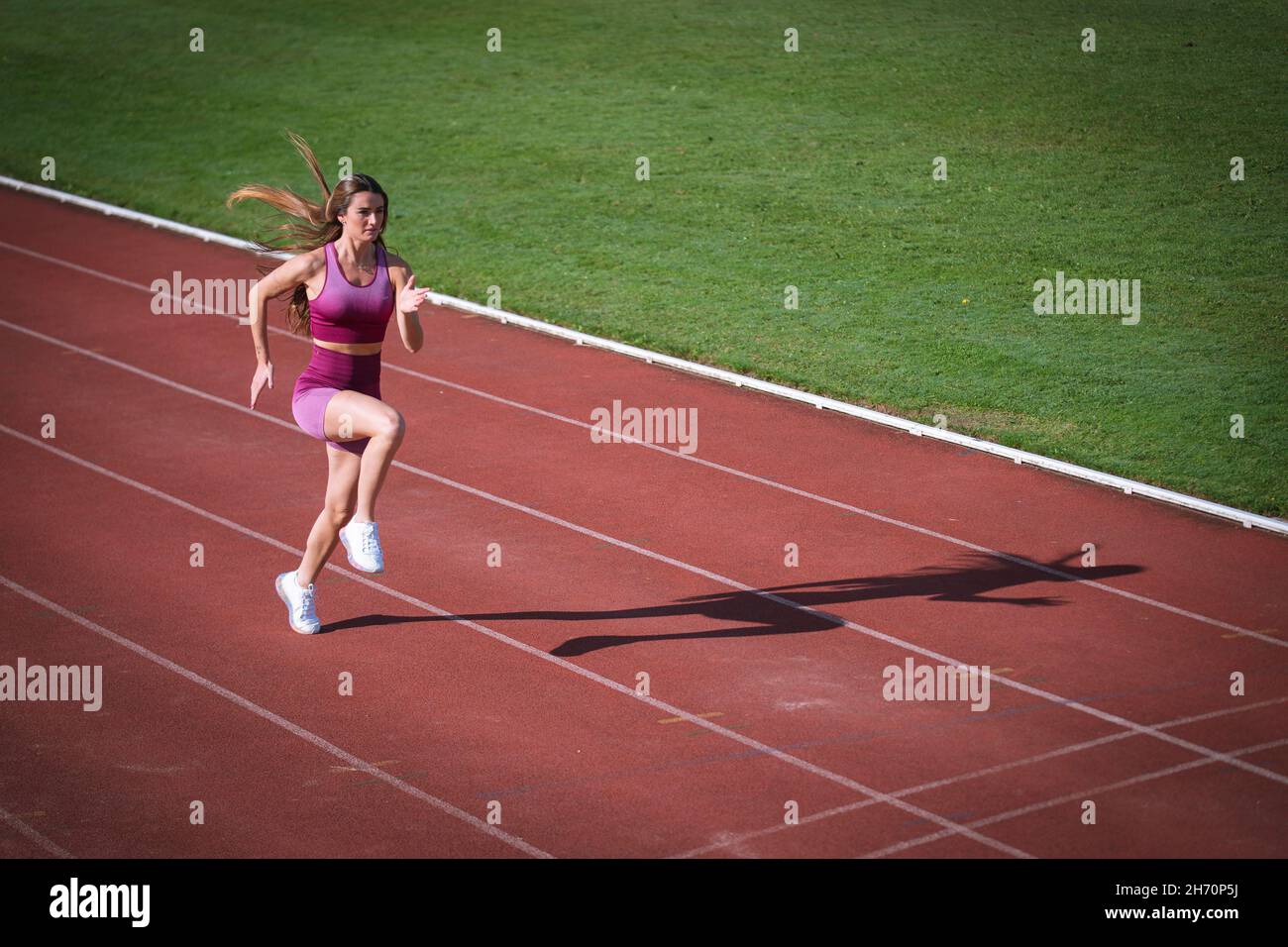 Girl model athlete running on the running track Stock Photo - Alamy