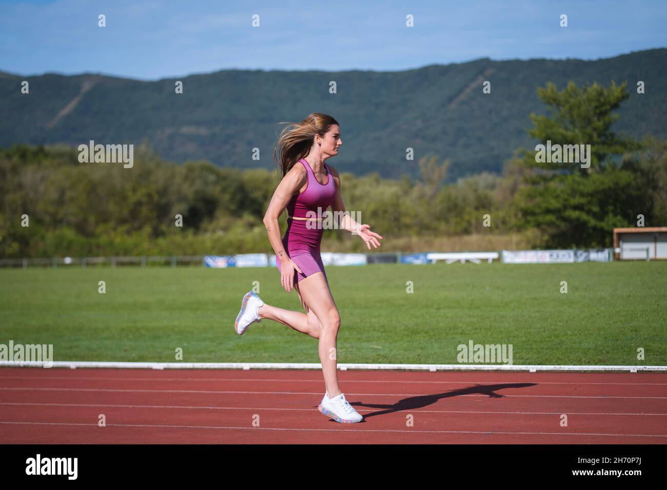 Girl model athlete running on the running track Stock Photo - Alamy