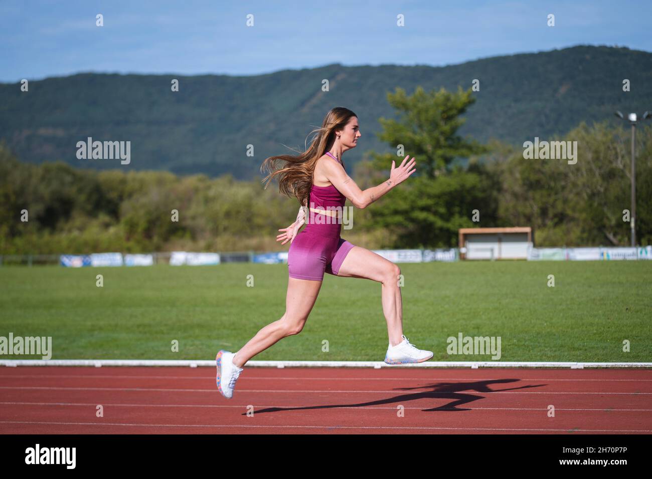 Girl model athlete running on the running track Stock Photo - Alamy
