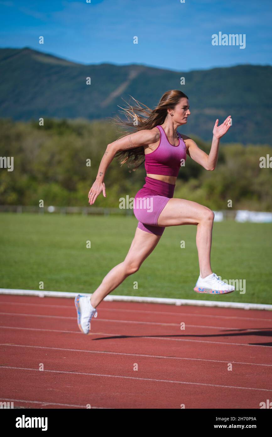 Girl model athlete running on the running track Stock Photo - Alamy