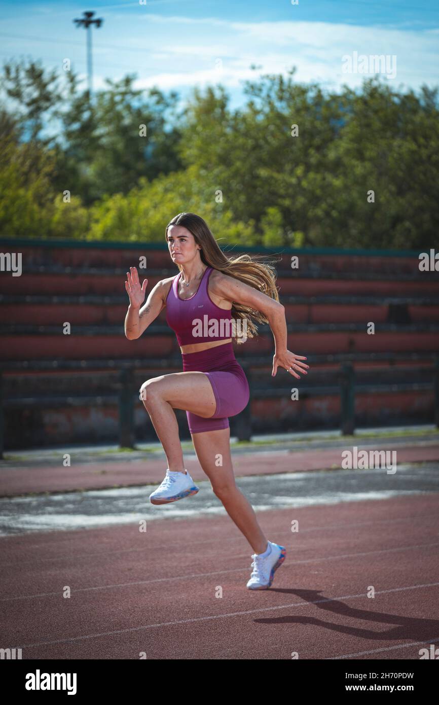 Girl model athlete running on the running track Stock Photo - Alamy