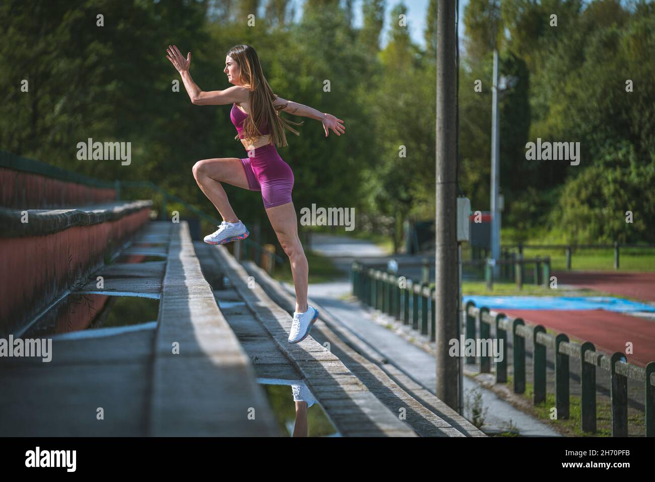 Athlete model girl walking up stairs on the running track Stock Photo ...