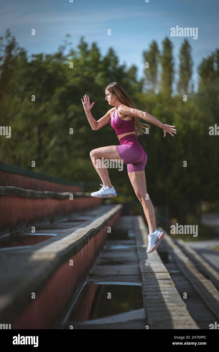 Athlete model girl walking up stairs on the running track Stock Photo ...