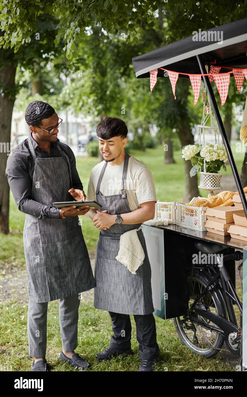 Men at food stall Stock Photo - Alamy