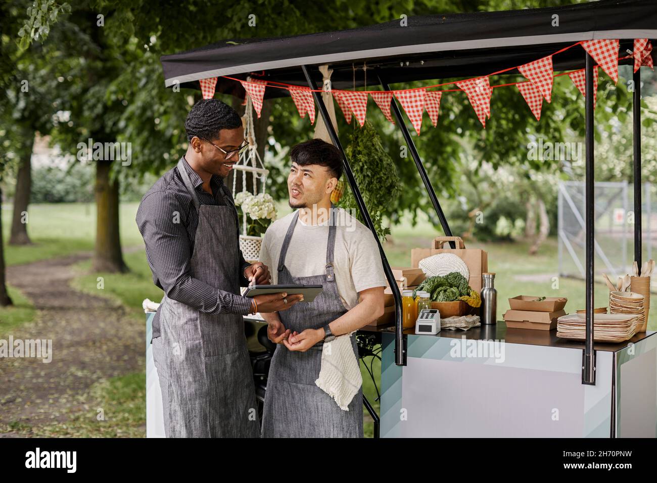 Men at food stall Stock Photo - Alamy