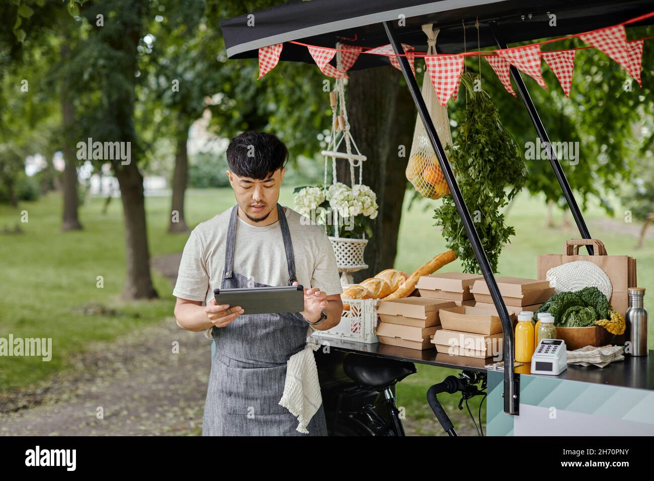 Man standing in front of food stall Stock Photo - Alamy