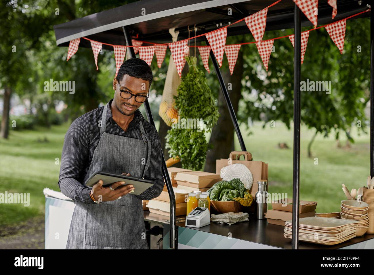 Man at food stall Stock Photo - Alamy