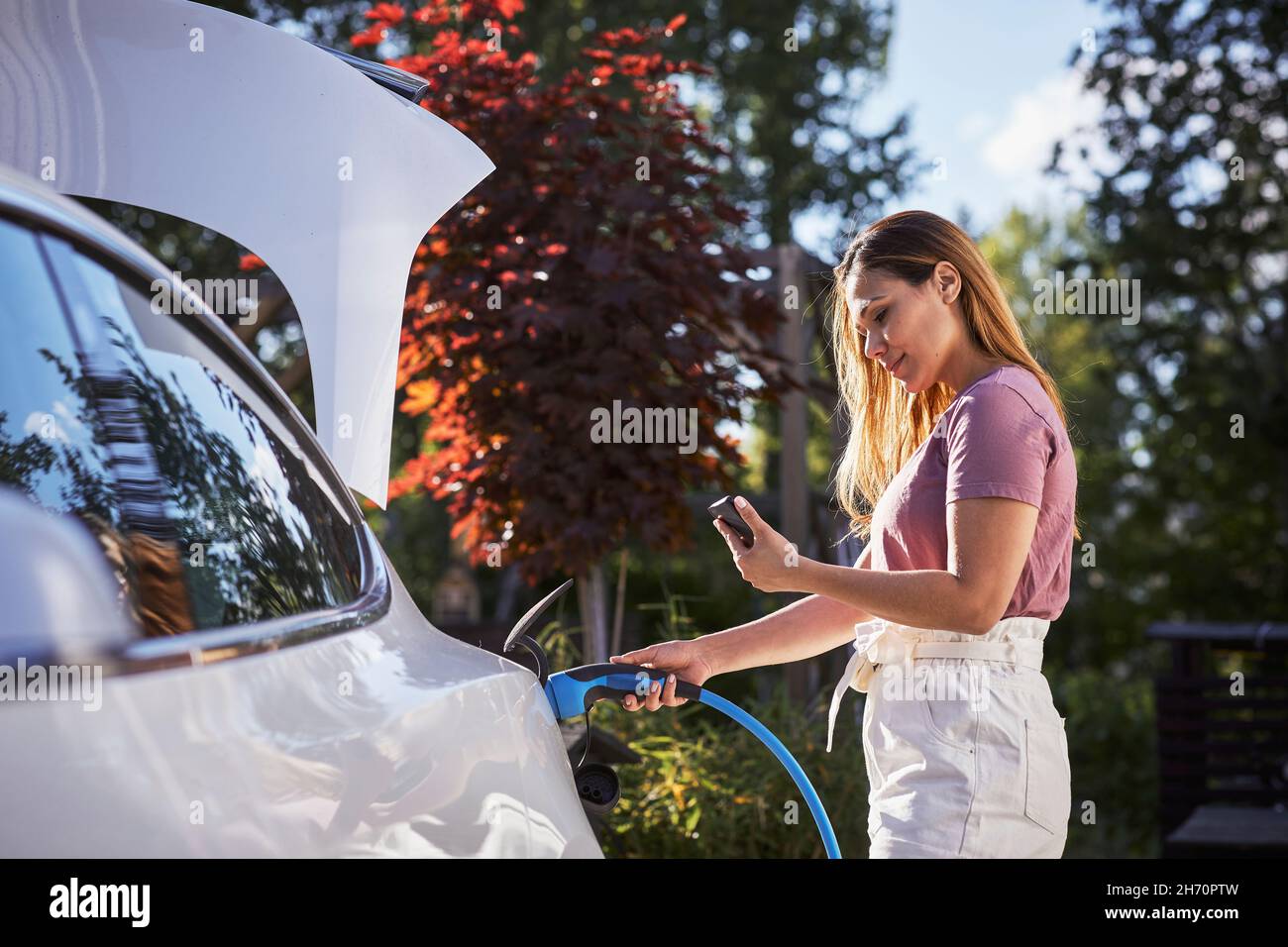Woman charging electric car station hi-res stock photography and images ...