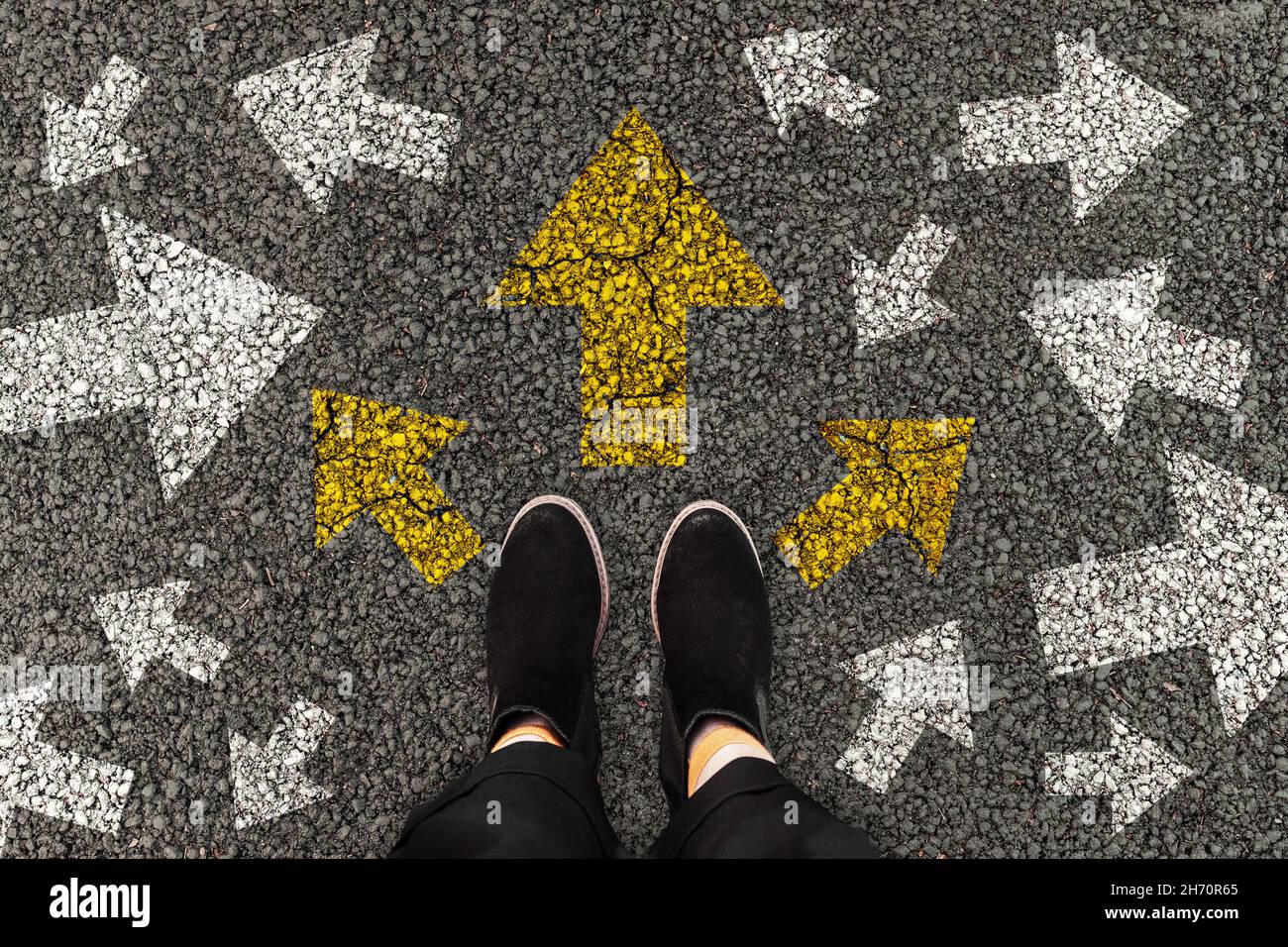 Person standing on road with arrow markings pointing in different ...
