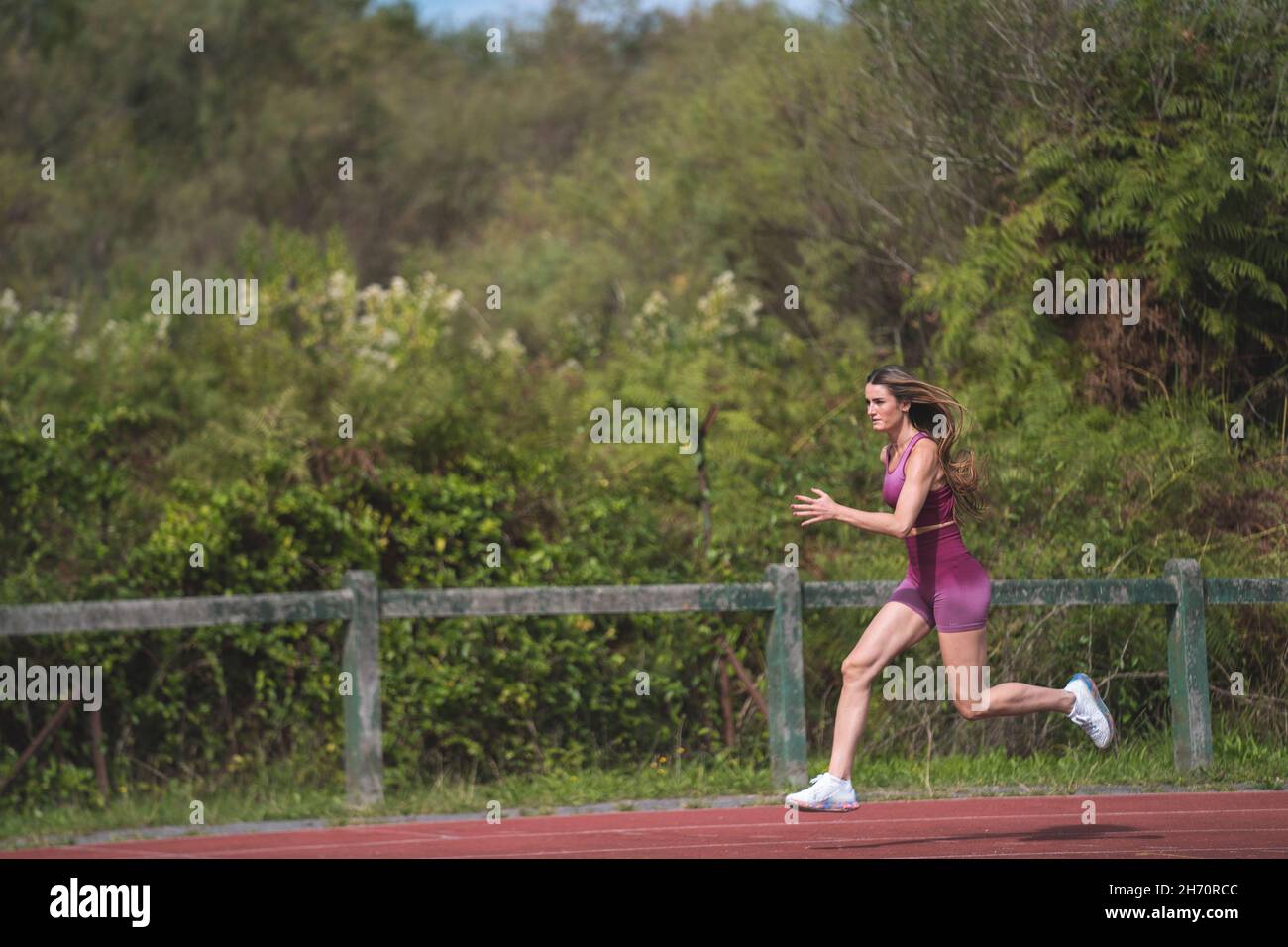 Girl model athlete running on the running track Stock Photo - Alamy