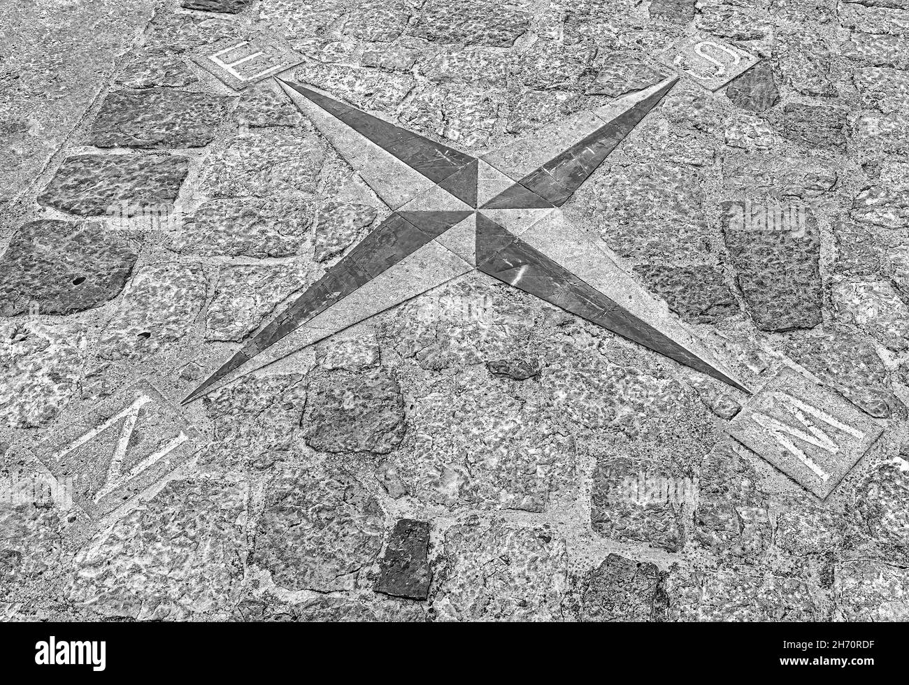 A navigational compass laid out on the pavement. Arrows pointing north ...