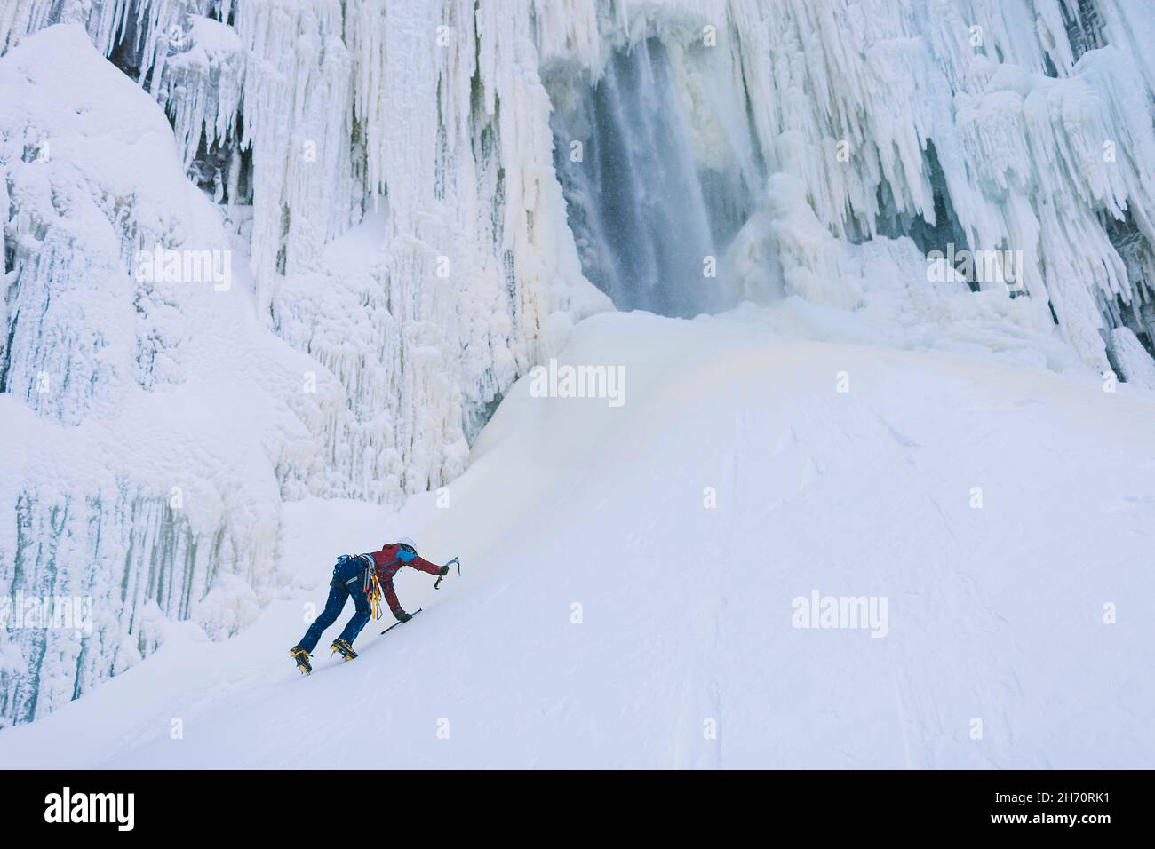 Female ice climber ascending snowy hill Stock Photo - Alamy