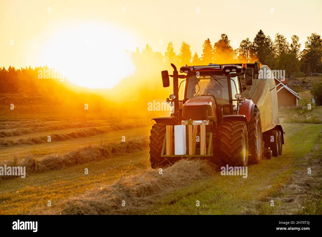 Tractor with baler on field Stock Photo - Alamy
