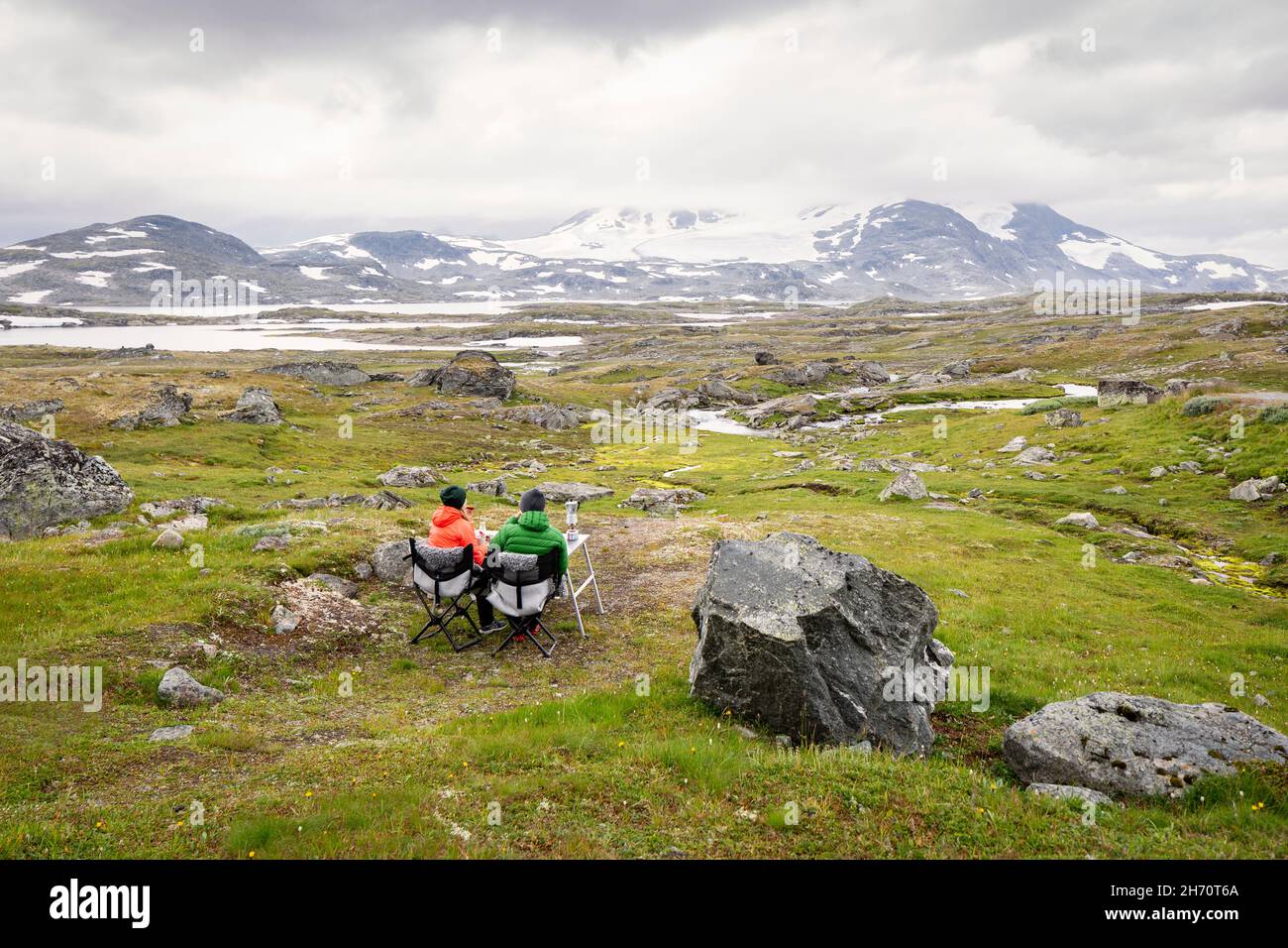 Hikers relaxing, mountains in background Stock Photo - Alamy