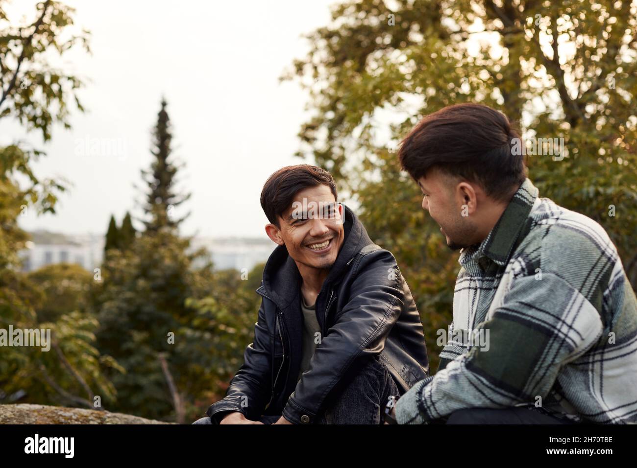 Young men talking outdoors Stock Photo - Alamy